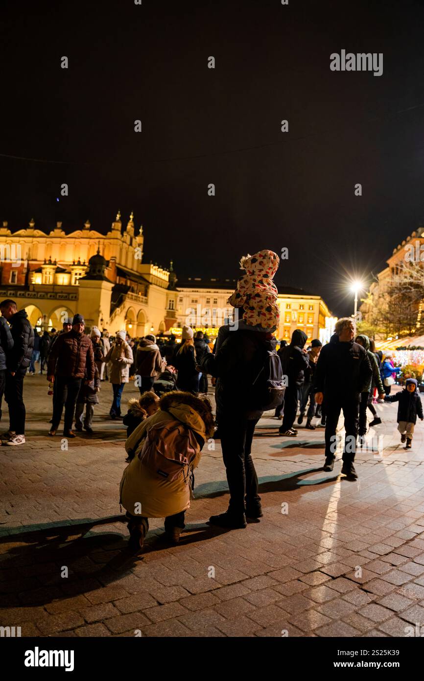Krakow, Poland - December 25, 2024: A busy plaza at night featuring ...