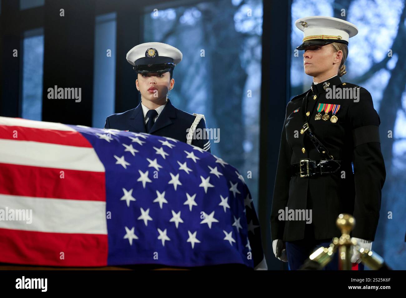 Members of the joint services military honor guard stand next to the casket bearing the remains ...