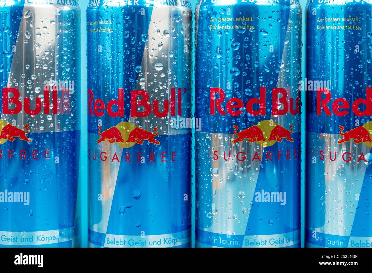 Four cans of Red Bull Sugarfree soda are lined up next to each other ...