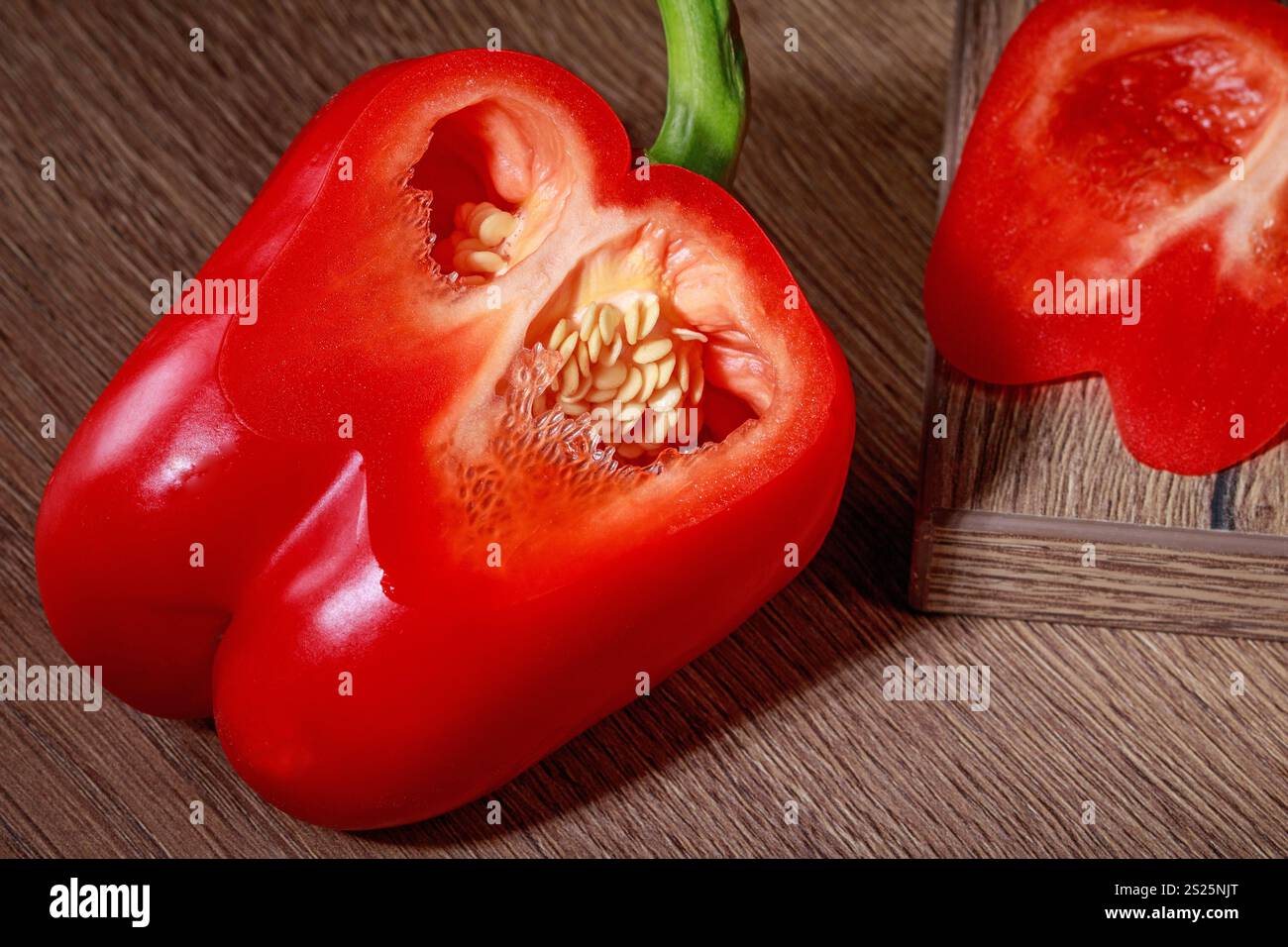 Cut red paprika on kitchen table, close-up, seeds visible in cut Stock ...