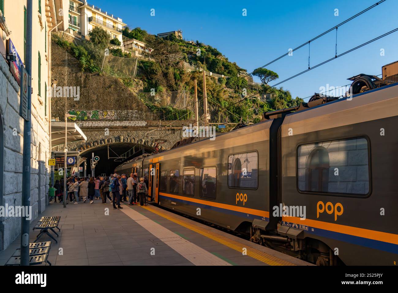 Passengers board a Trenitalia Pop passenger train at the station in ...