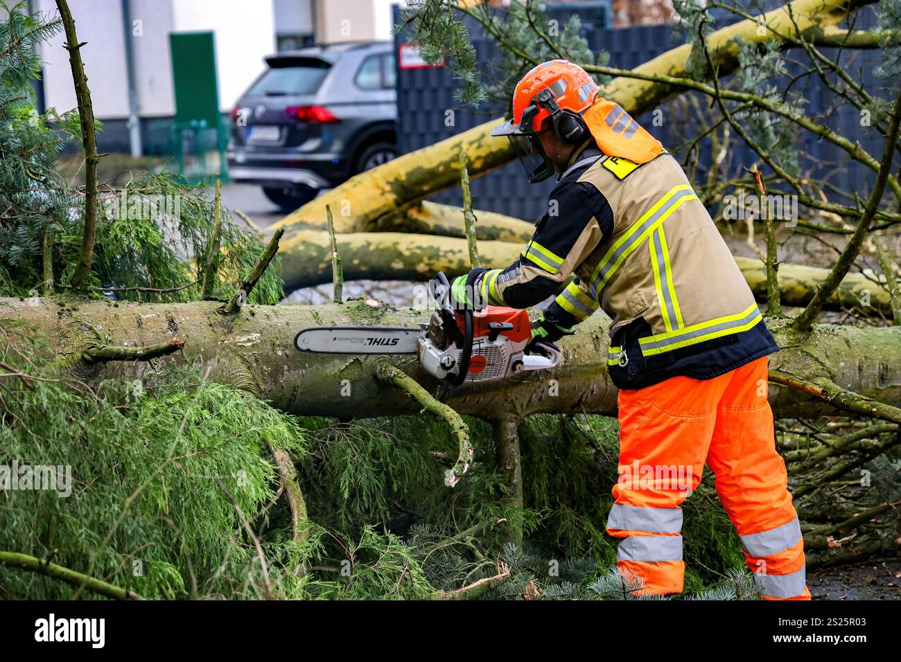 Solingen, Germany. 06th Jan, 2025. A firefighter uses a chainsaw to cut ...