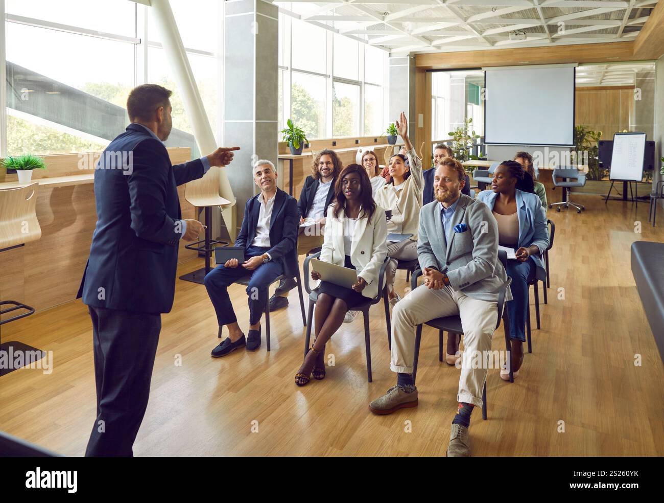 Group of company employees or a team of staff sitting on chairs on ...