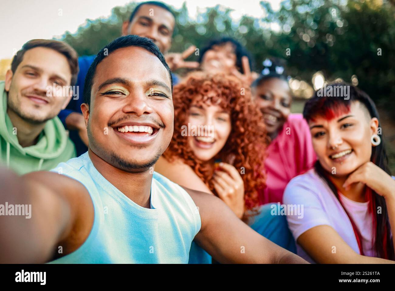 Young diverse people smiling at mobile phone camera at city park ...