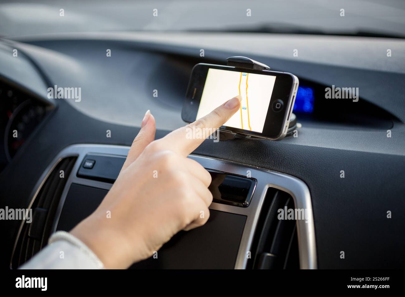 Female driver using touchscreen smartphone with GPS navigation Stock ...