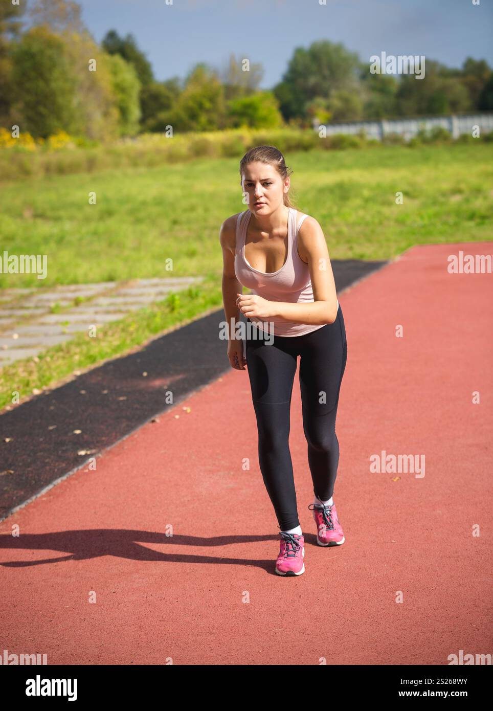 Beautiful slim woman running at hot day on sports arena Stock Photo - Alamy
