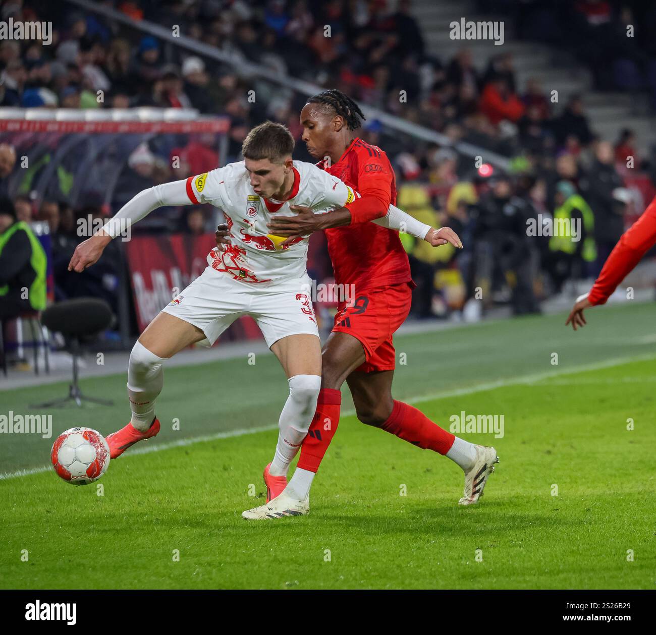 Mathys Tel (FC Bayern Muenchen, #39) im Zweikampf mit Tim Trummer (FC ...