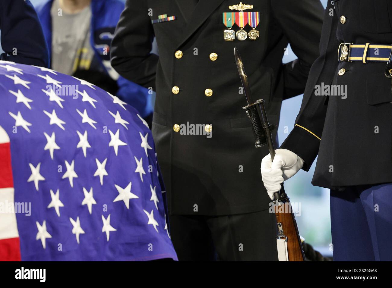 Members of the joint services military honor guard stand at attention at the casket of former ...