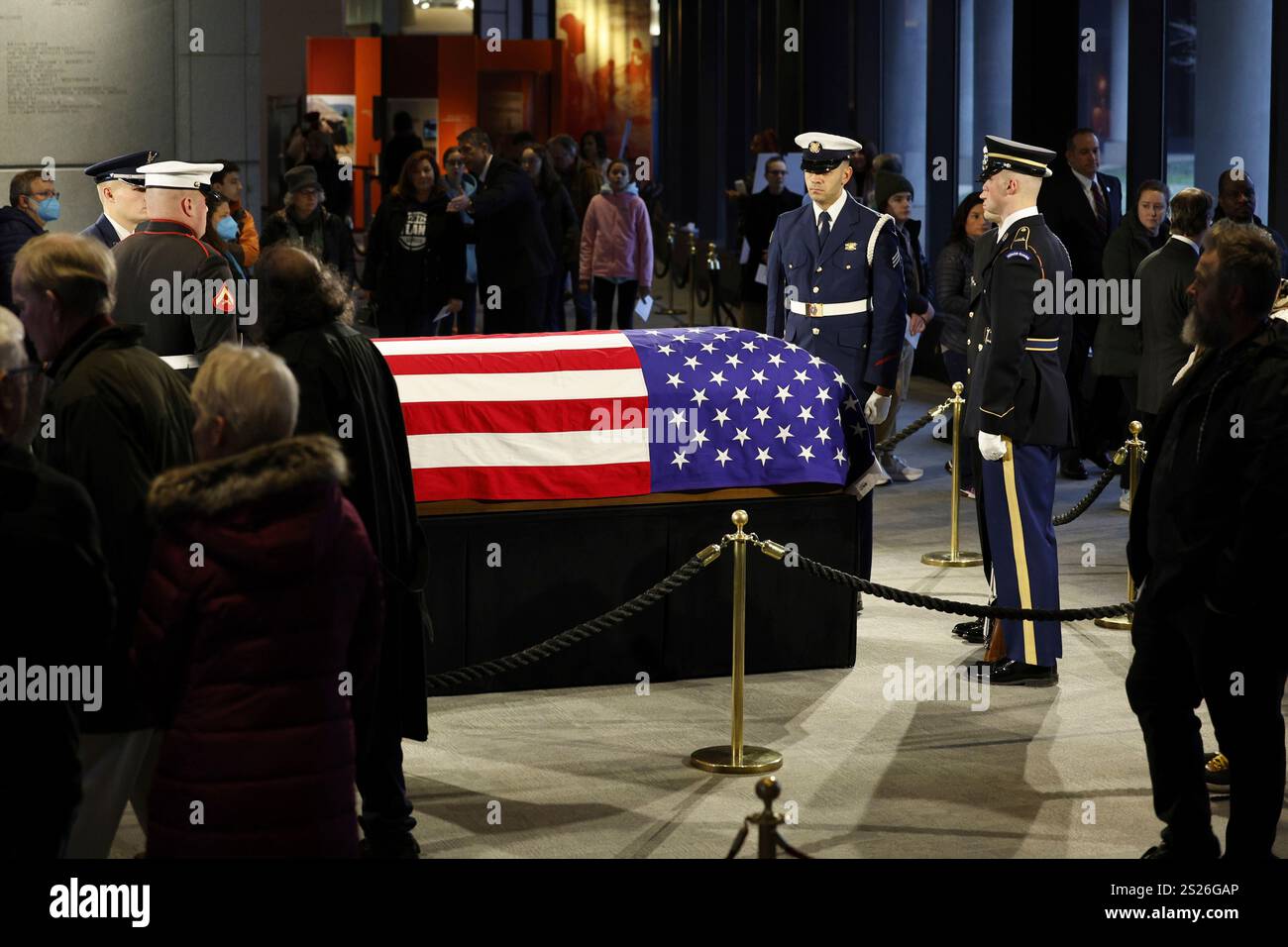Members of the joint services military honor guard stand at attention at the casket of former ...