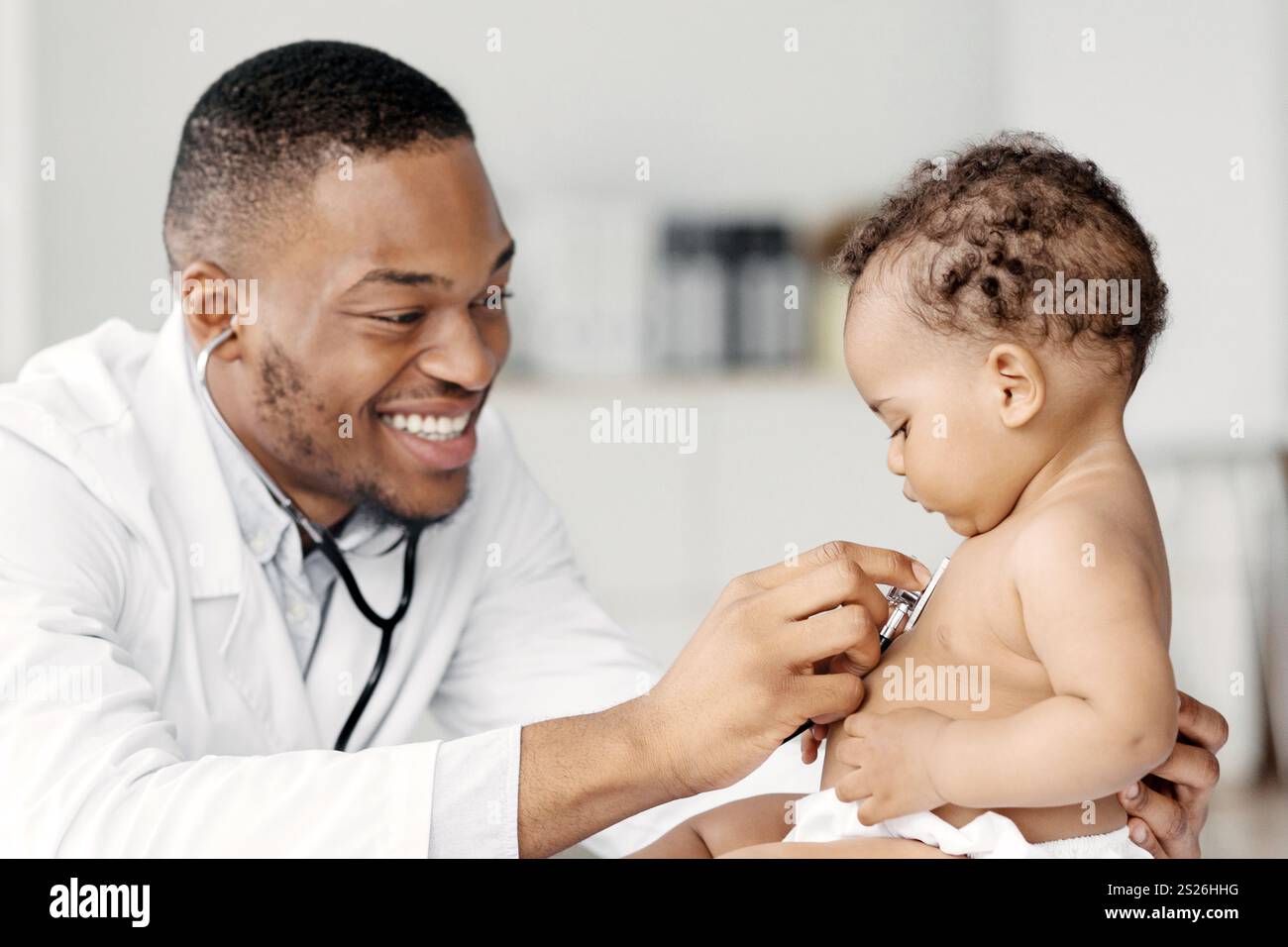 Black Pediatrician Doctor Doing Check Up To Cute Newborn Baby In Diaper ...