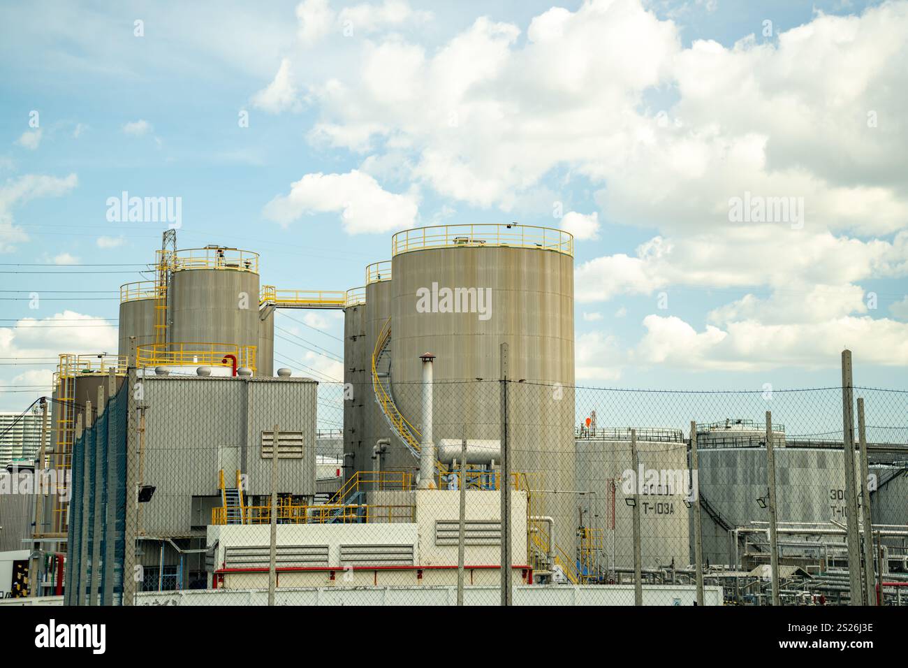 Large industrial storage tanks stand prominently at a manufacturing ...