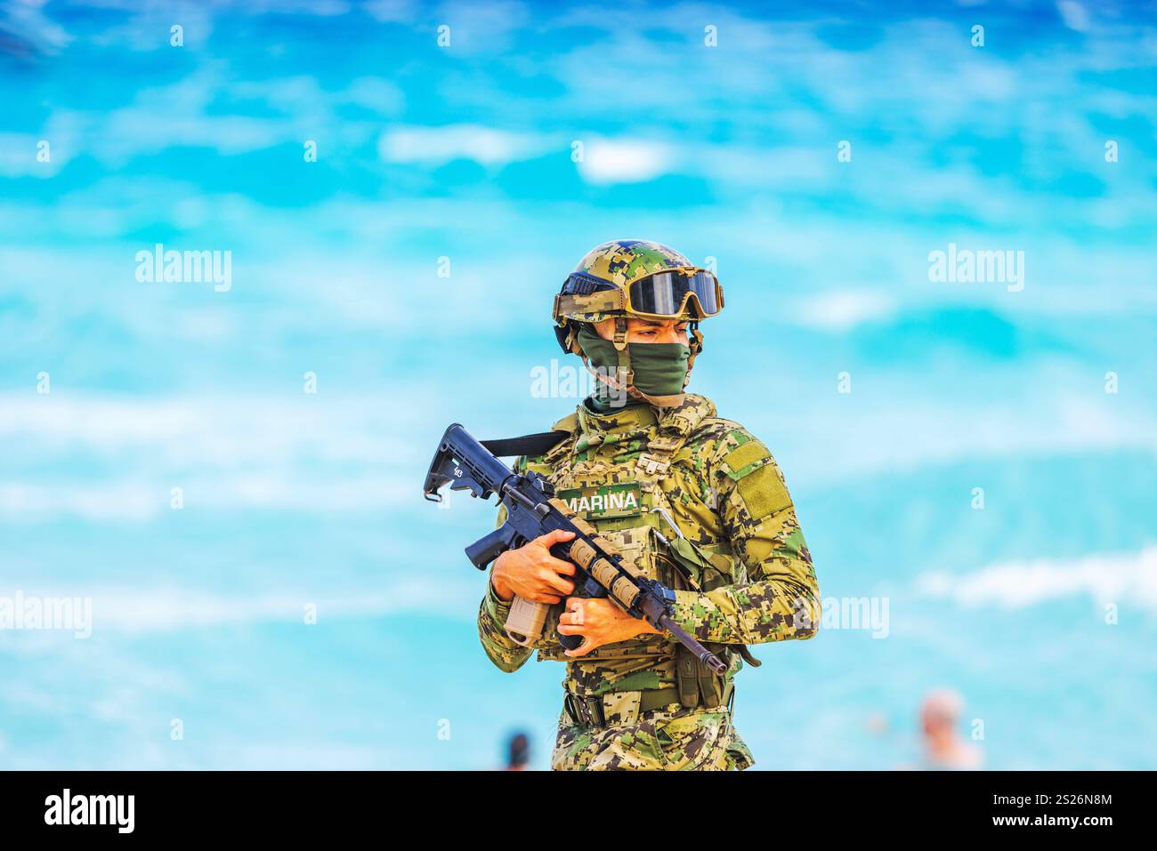 Military soldier in camouflage uniform holding automatic rifle on sandy ...