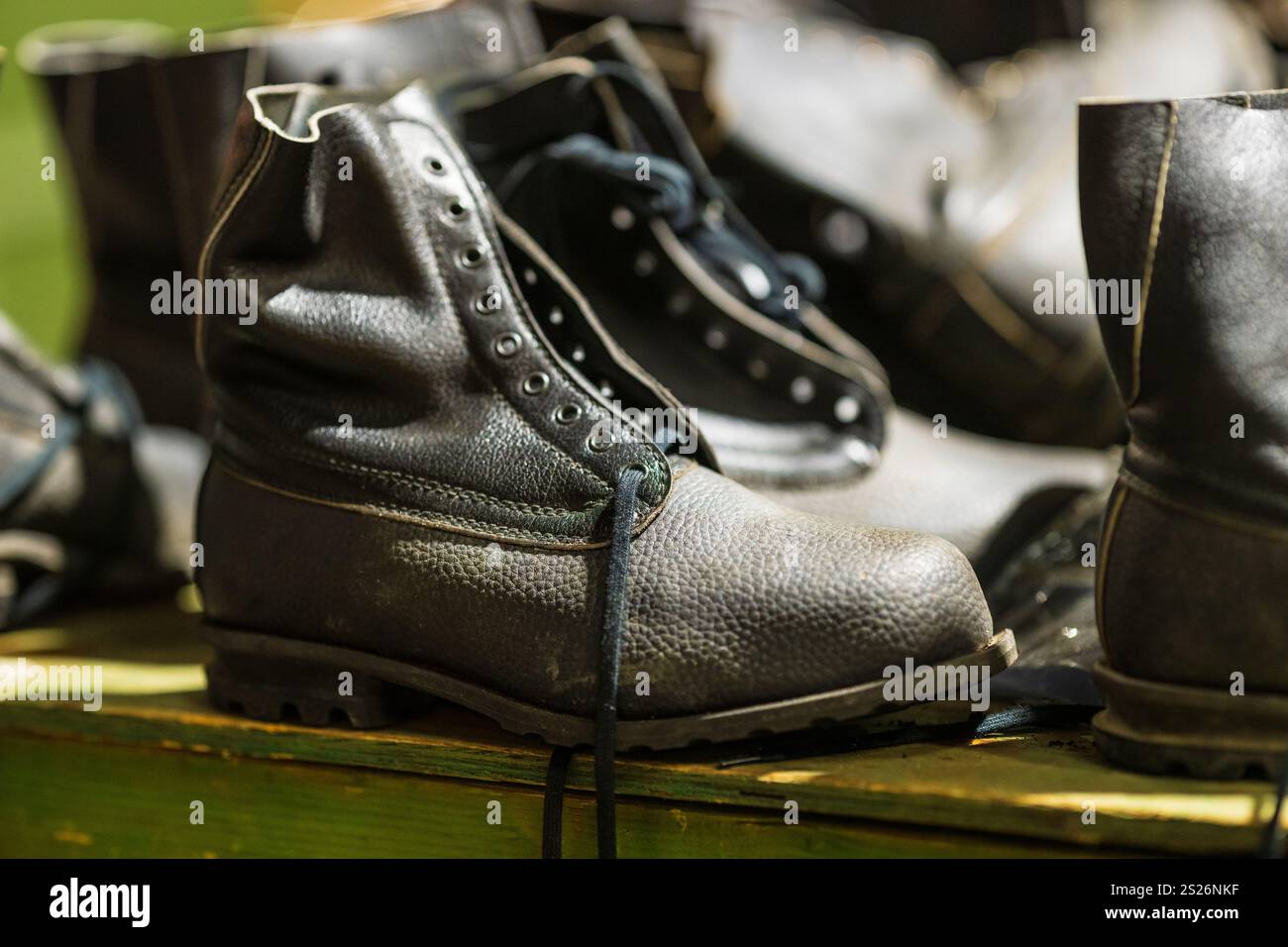 Surplus military boots in a warehouse Stock Photo - Alamy