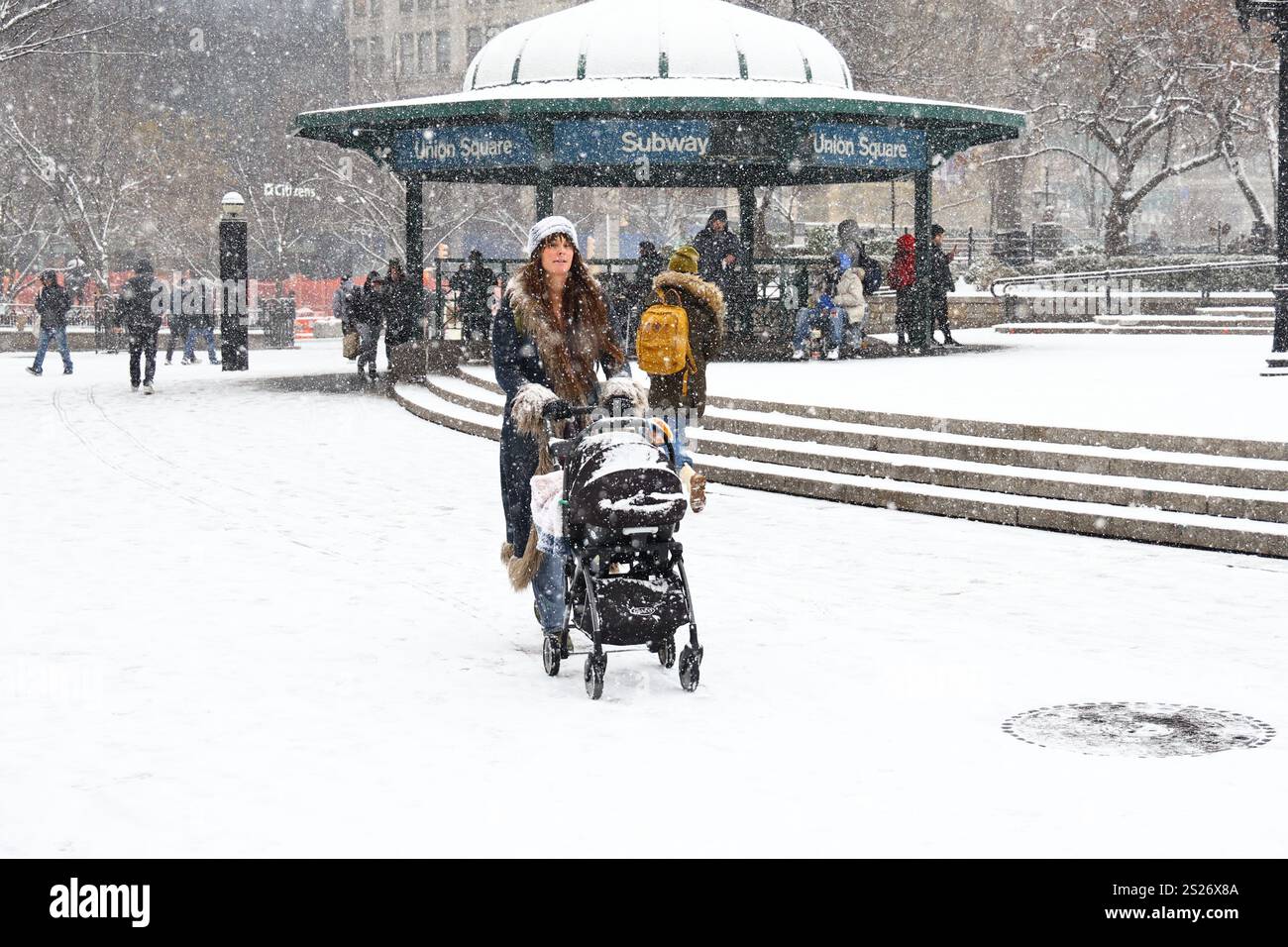 People walk through Union Square as the snow gets heavy in New York, N ...