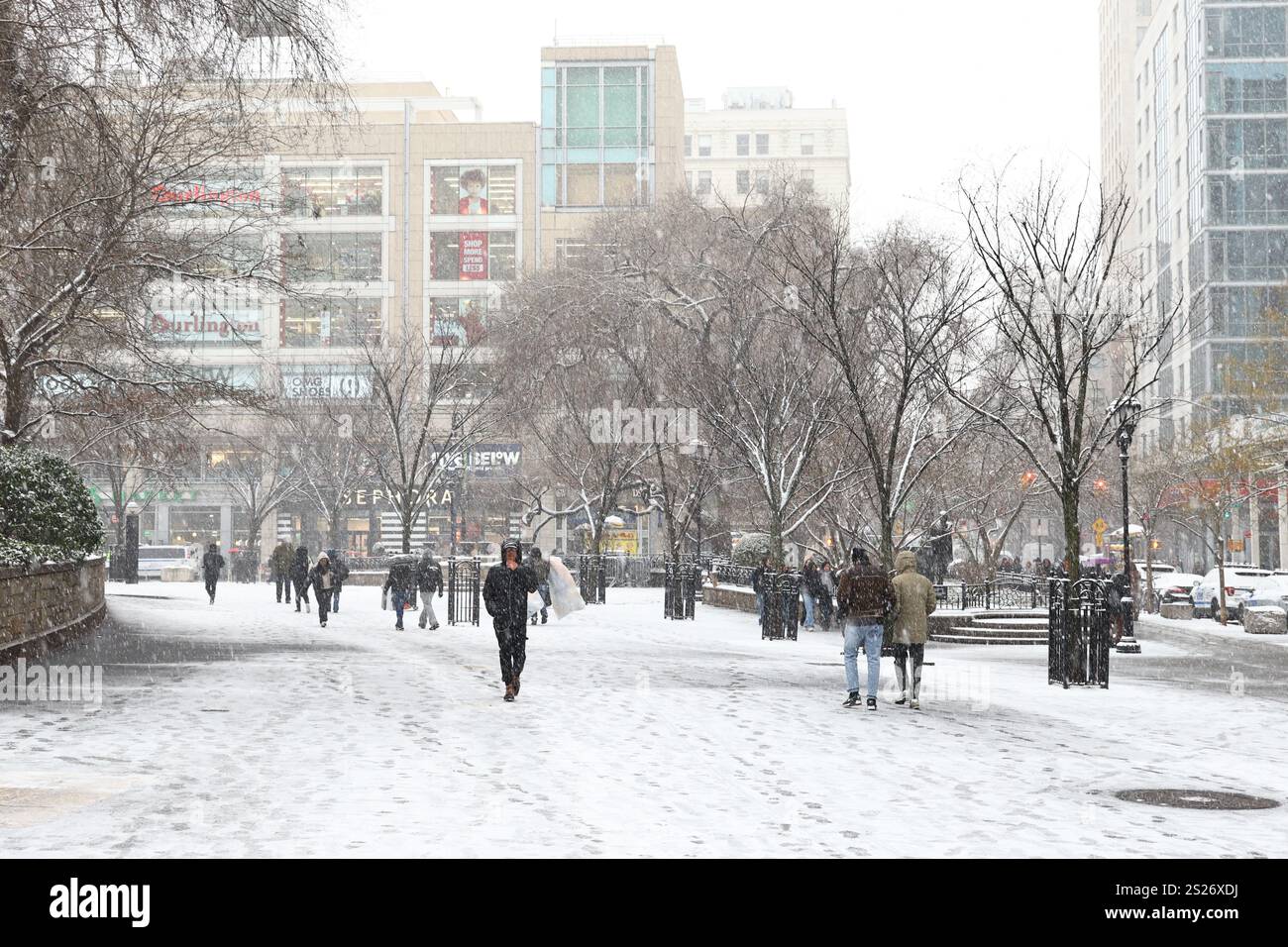 People walk through Union Square Park as snow falls heavily in New York ...