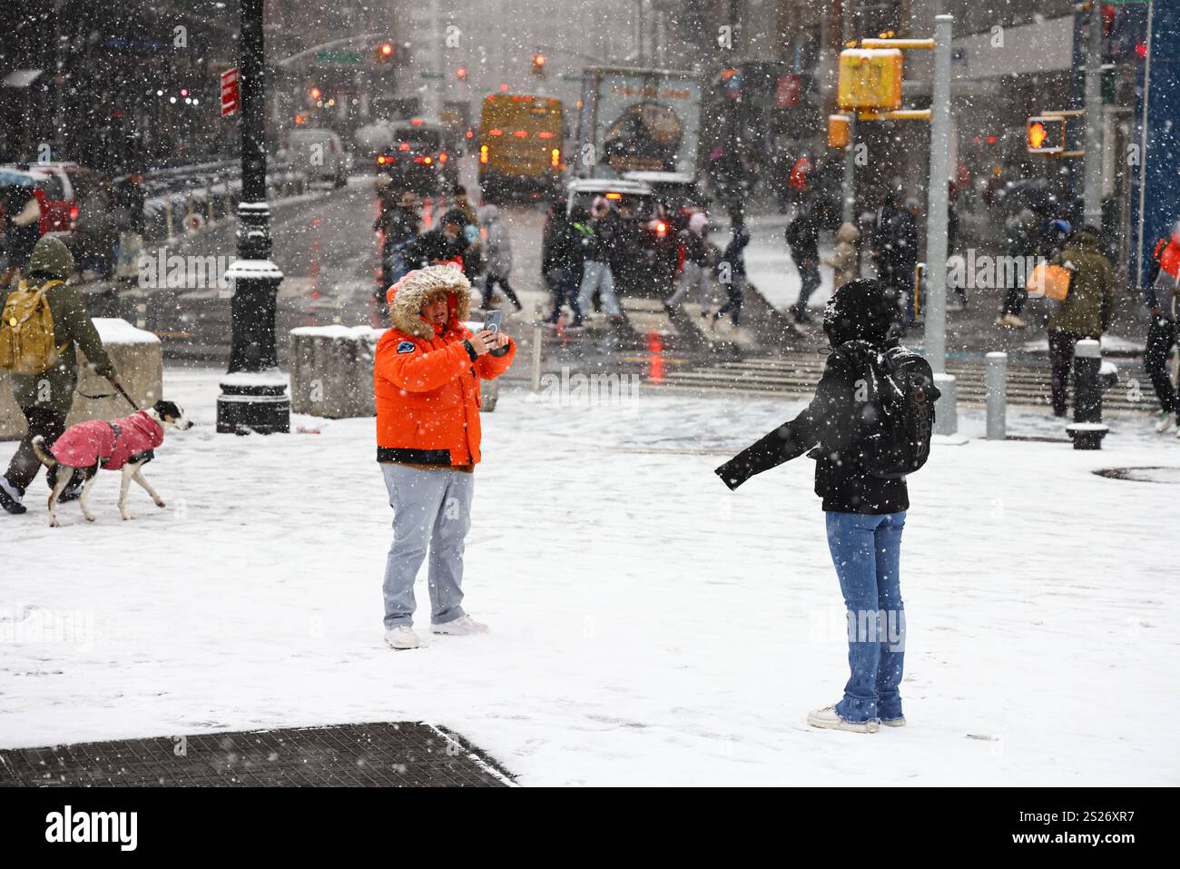 People take photos in Union Square Park as snow falls in New York, N.Y ...