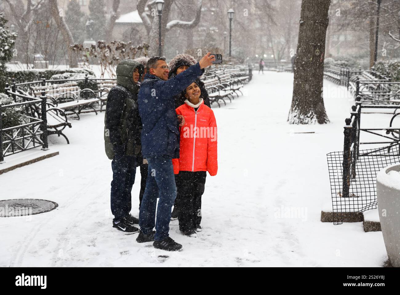 People take photos in Union Square Park as snow falls in New York, N.Y ...