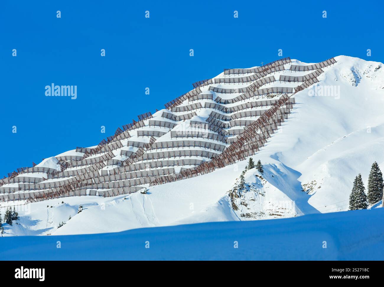 Winter mountain with snowy fir and metallic snow-barrier on slope Stock ...