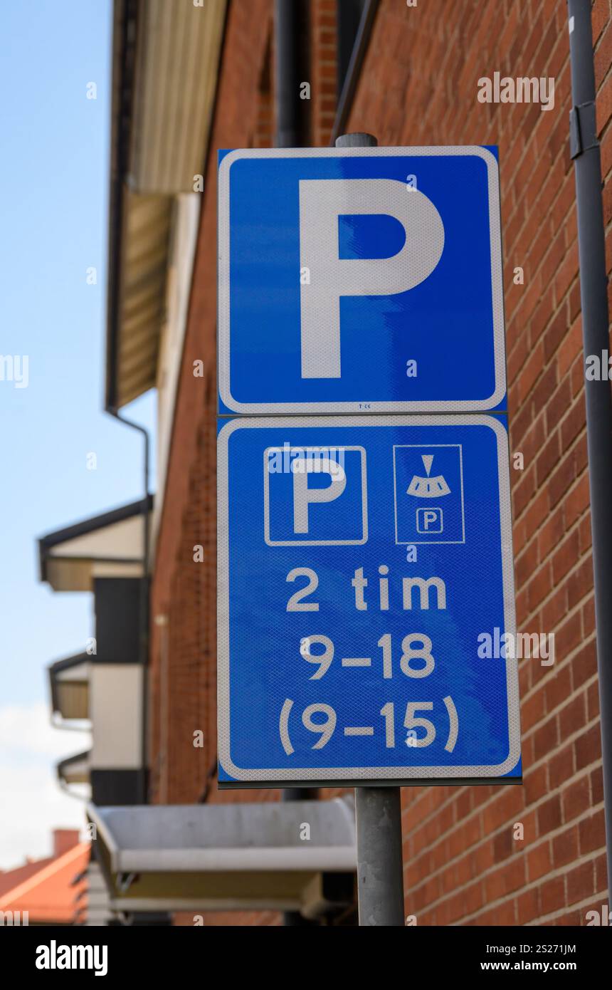 A blue parking sign indicates restrictions for two-hour parking between ...
