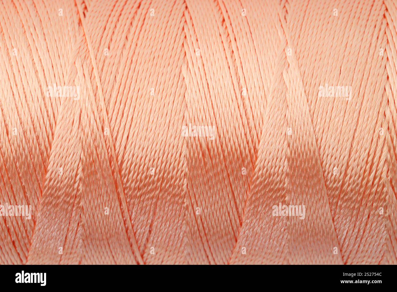 Beautiful peach sewing thread as background, closeup Stock Photo - Alamy