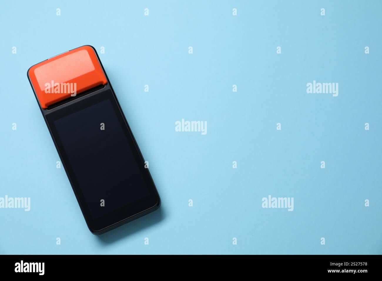 One payment terminal on light blue background, top view. Space for text ...