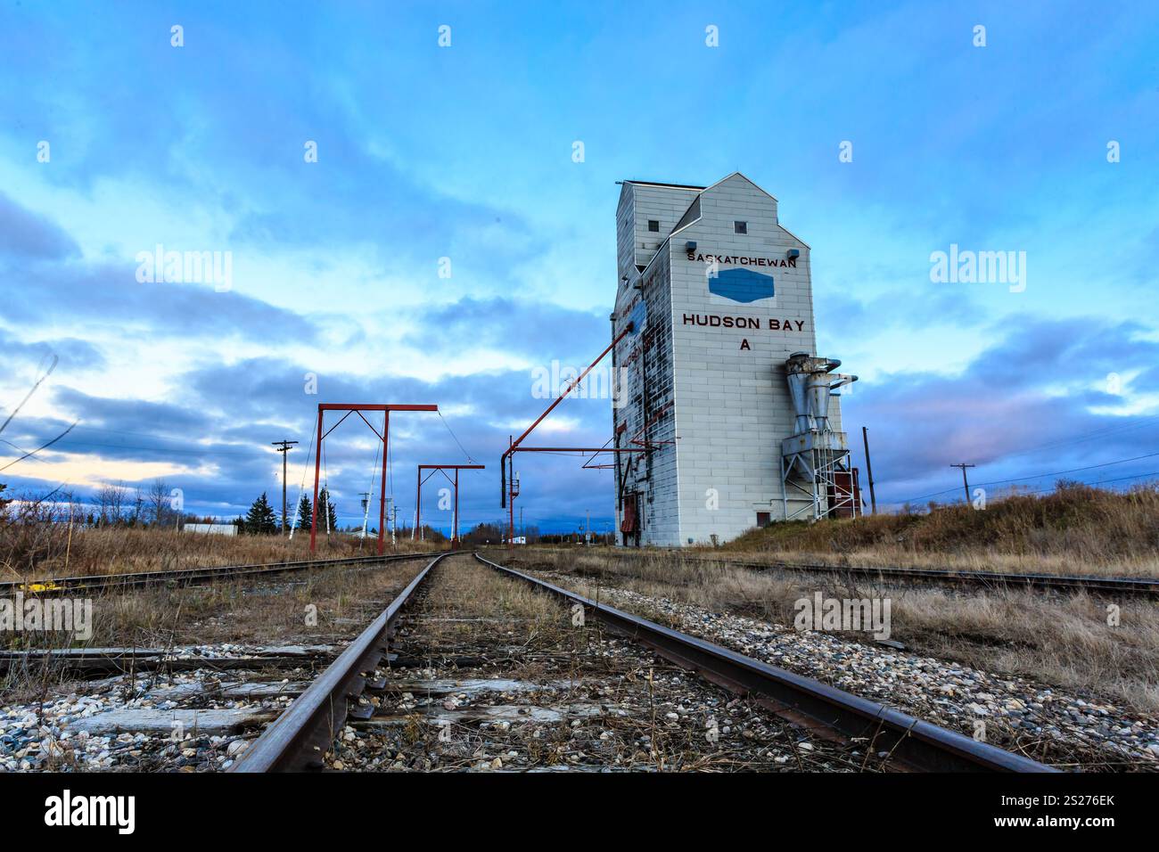 A train track with a grain silo in the background. The silo is called ...