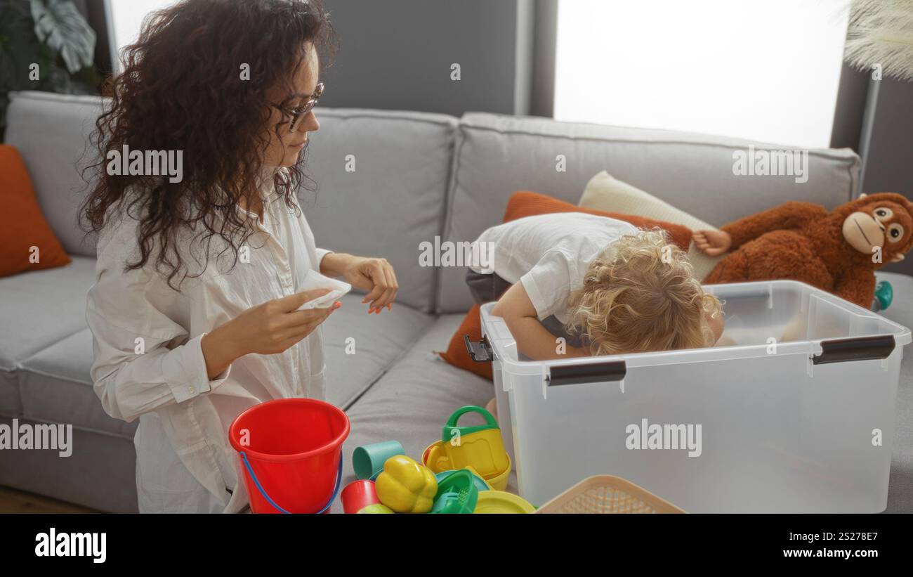 Woman and son playing together in a cozy living room surrounded by toys ...