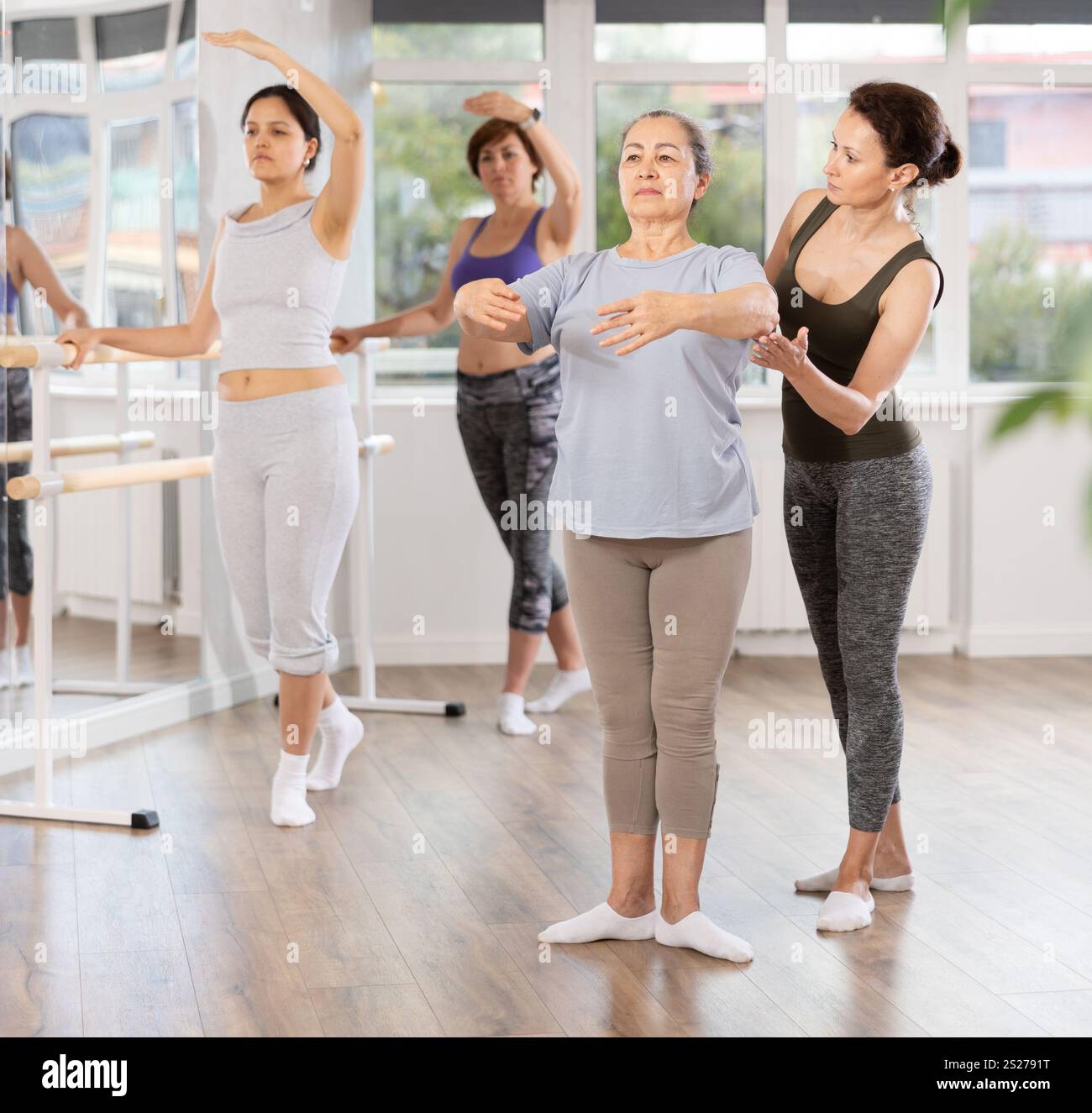 Ballet choreographer instructing senior woman in basic ballet ...