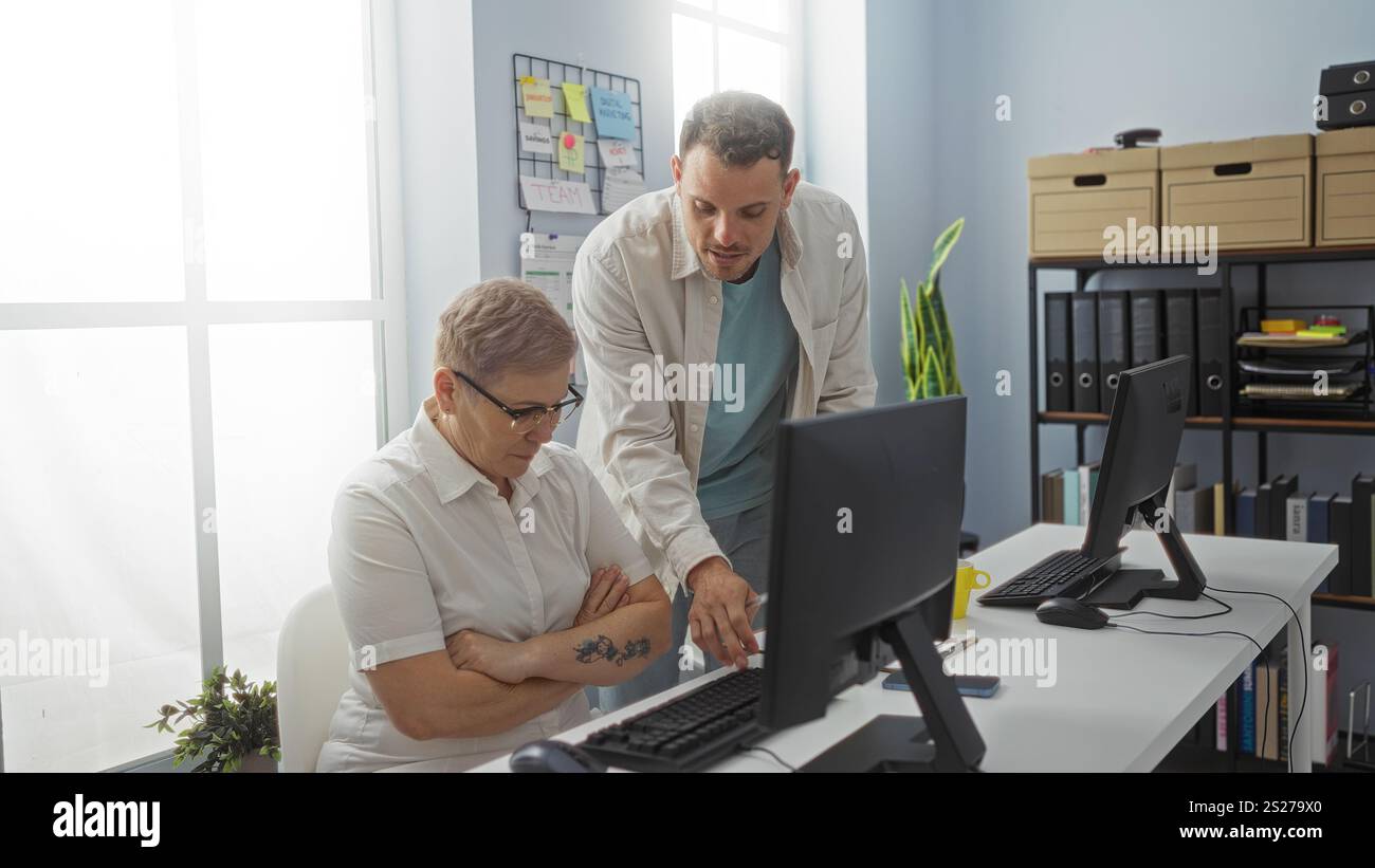 Man helping woman coworker in modern office, discussing project details ...