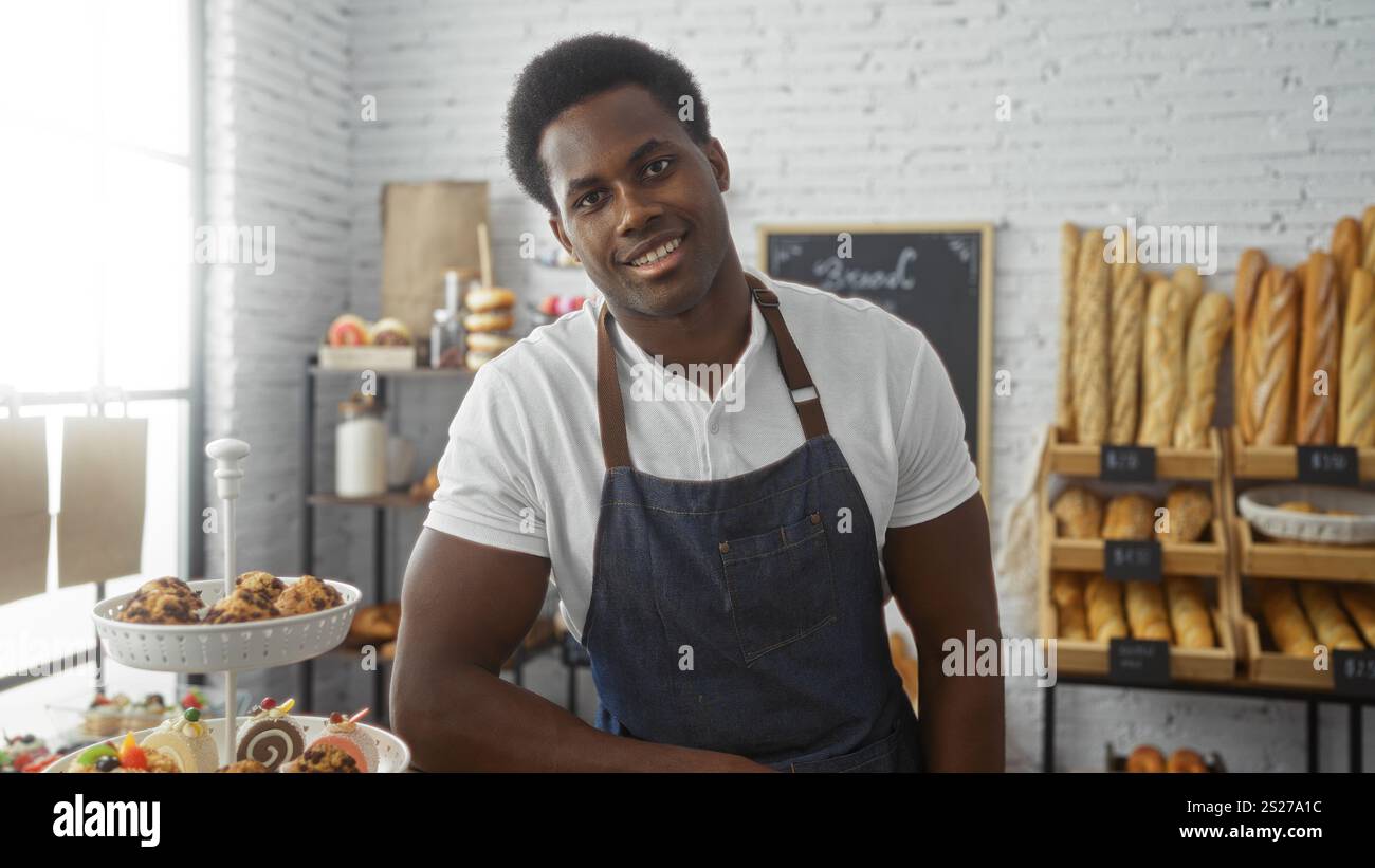 Handsome young man in a bakery setting, wearing an apron and smiling in ...