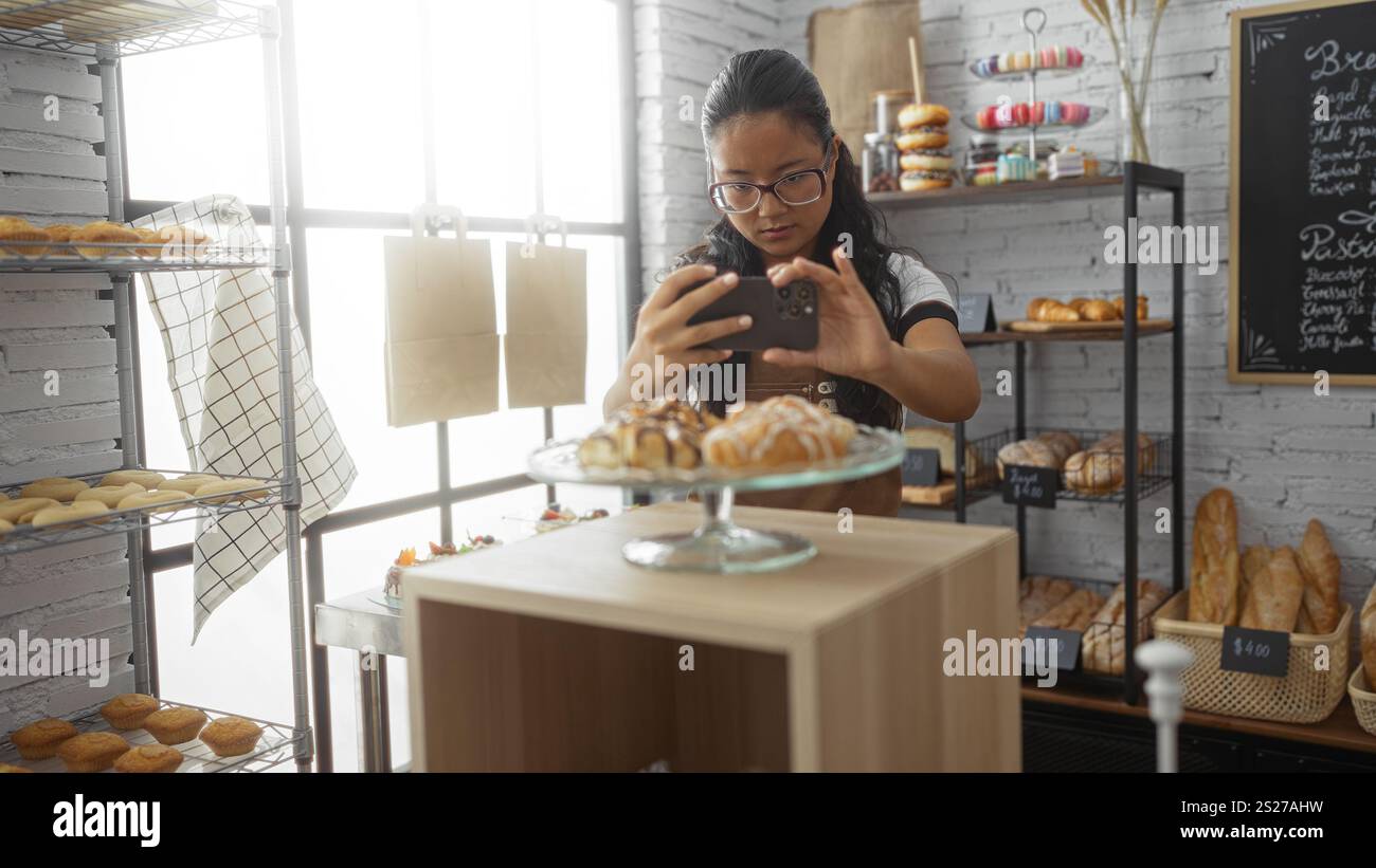 Young, chinese, woman photographing pastries in a bakery shop interior ...