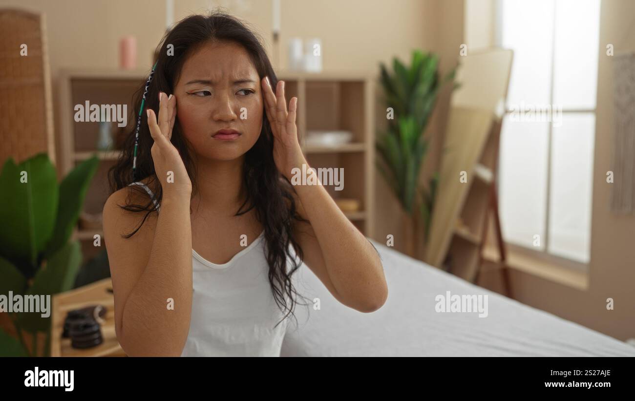 Young asian woman in a spa setting, expressing concern in a serene ...