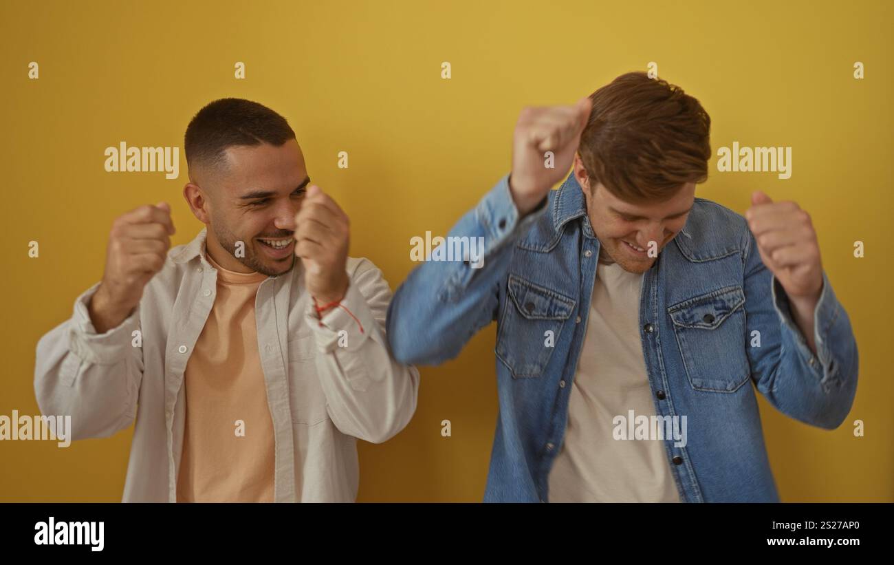 Two handsome men celebrating their friendship against a vibrant yellow ...
