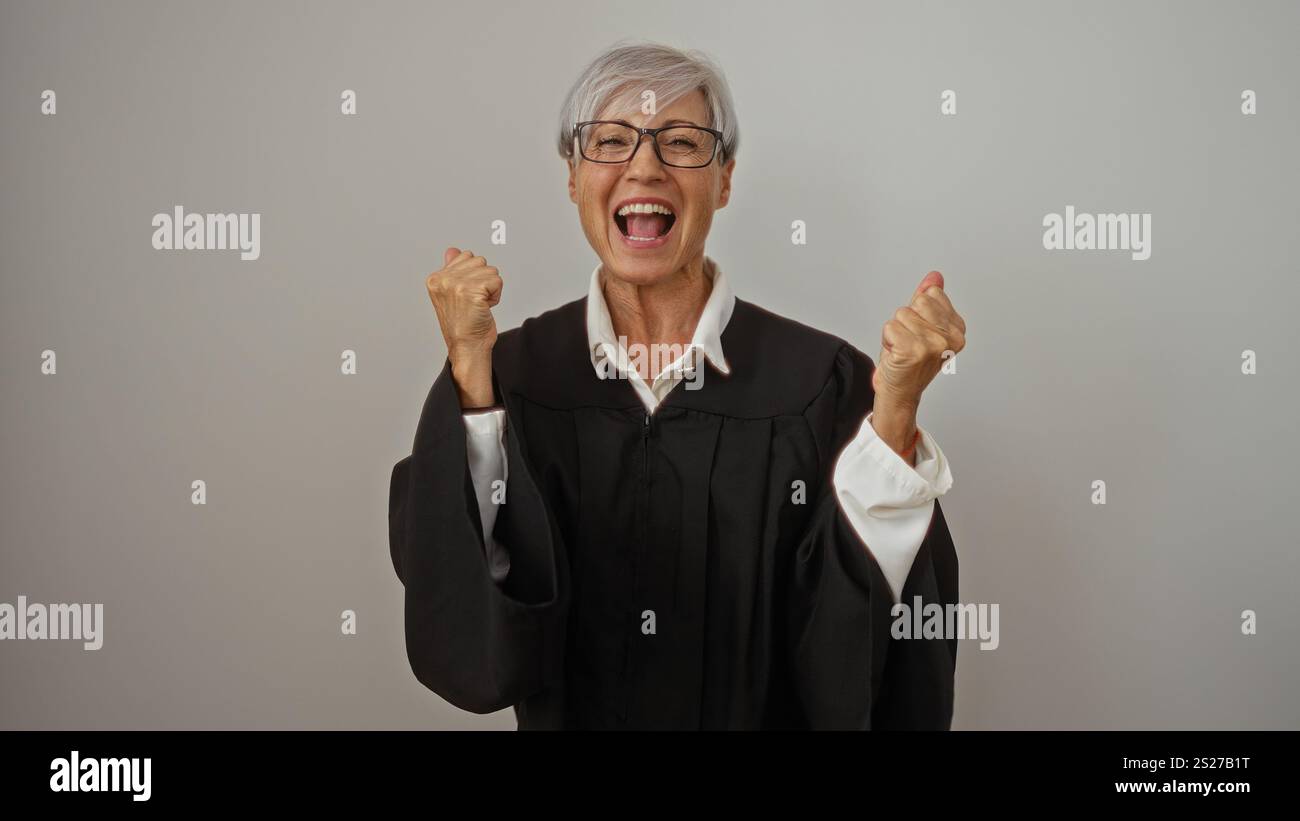 Woman celebrating while wearing black robe over white background ...