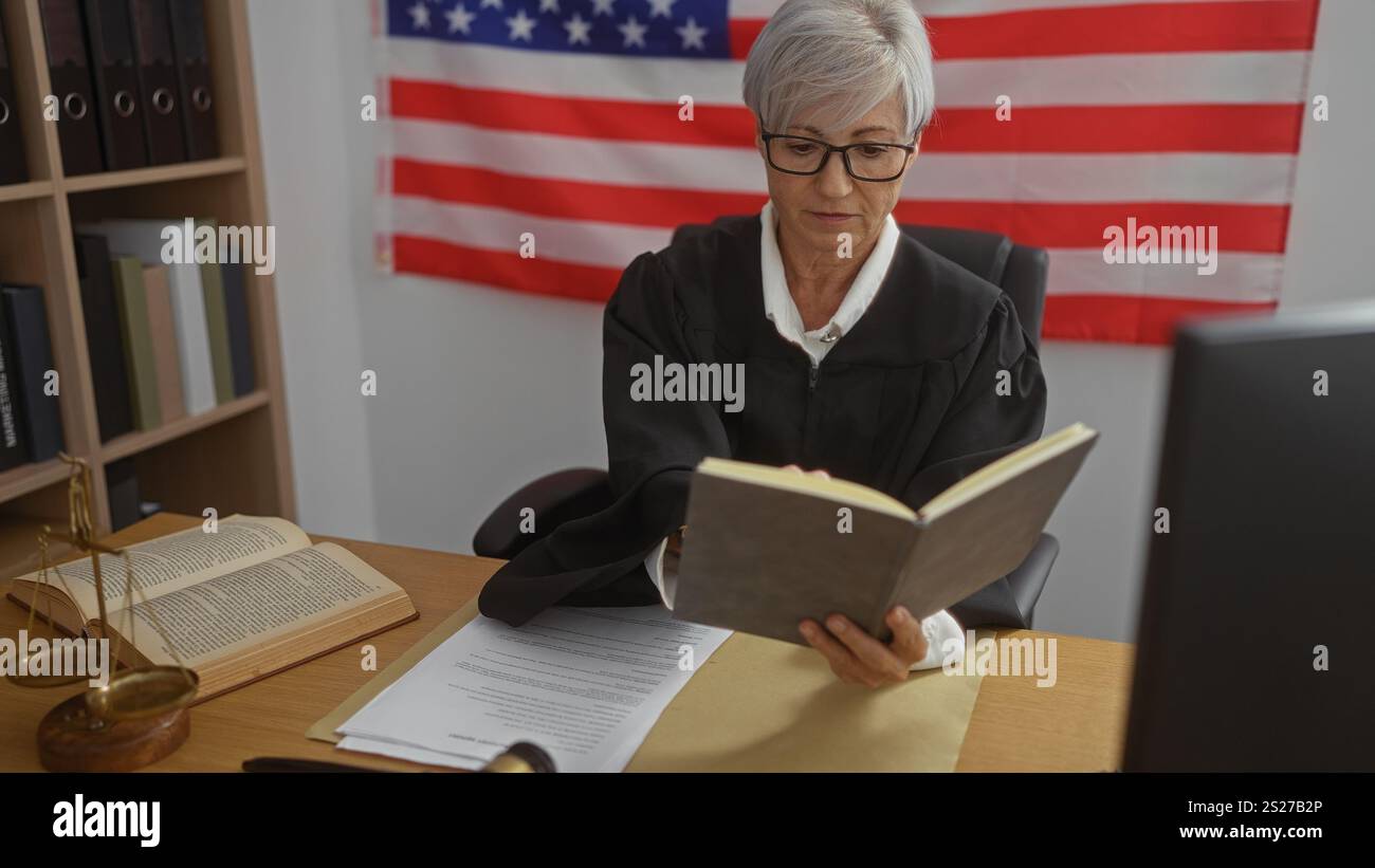 Mature female judge with grey hair reads a book in a courtroom with an ...