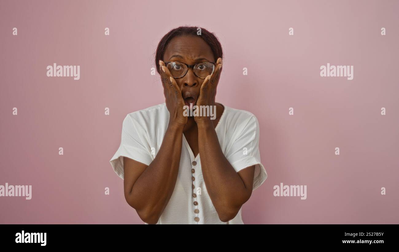 African woman expressing shock over isolated pink background Stock ...