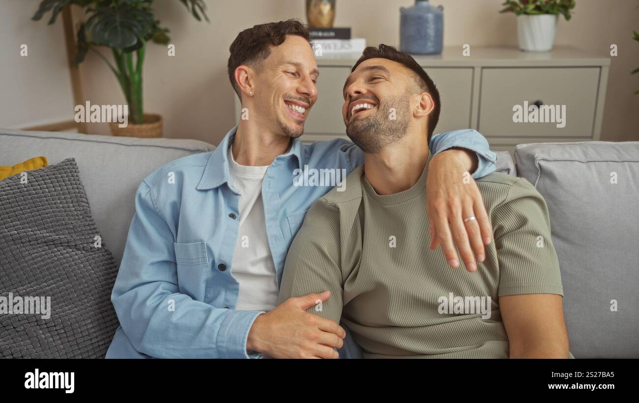 Loving men couple sharing a joyful moment on their living room couch ...
