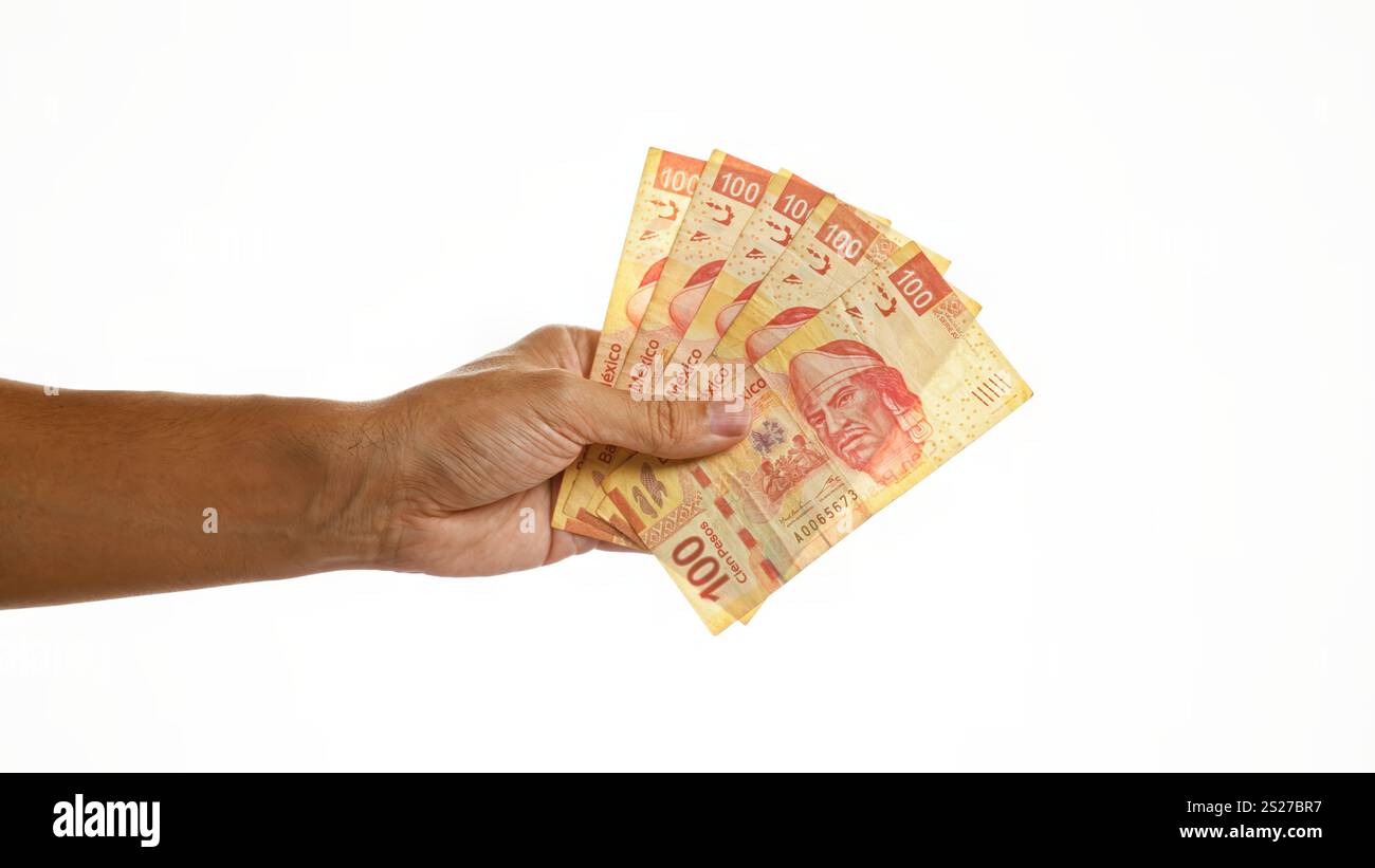 Hand holding mexican pesos against an isolated white background ...