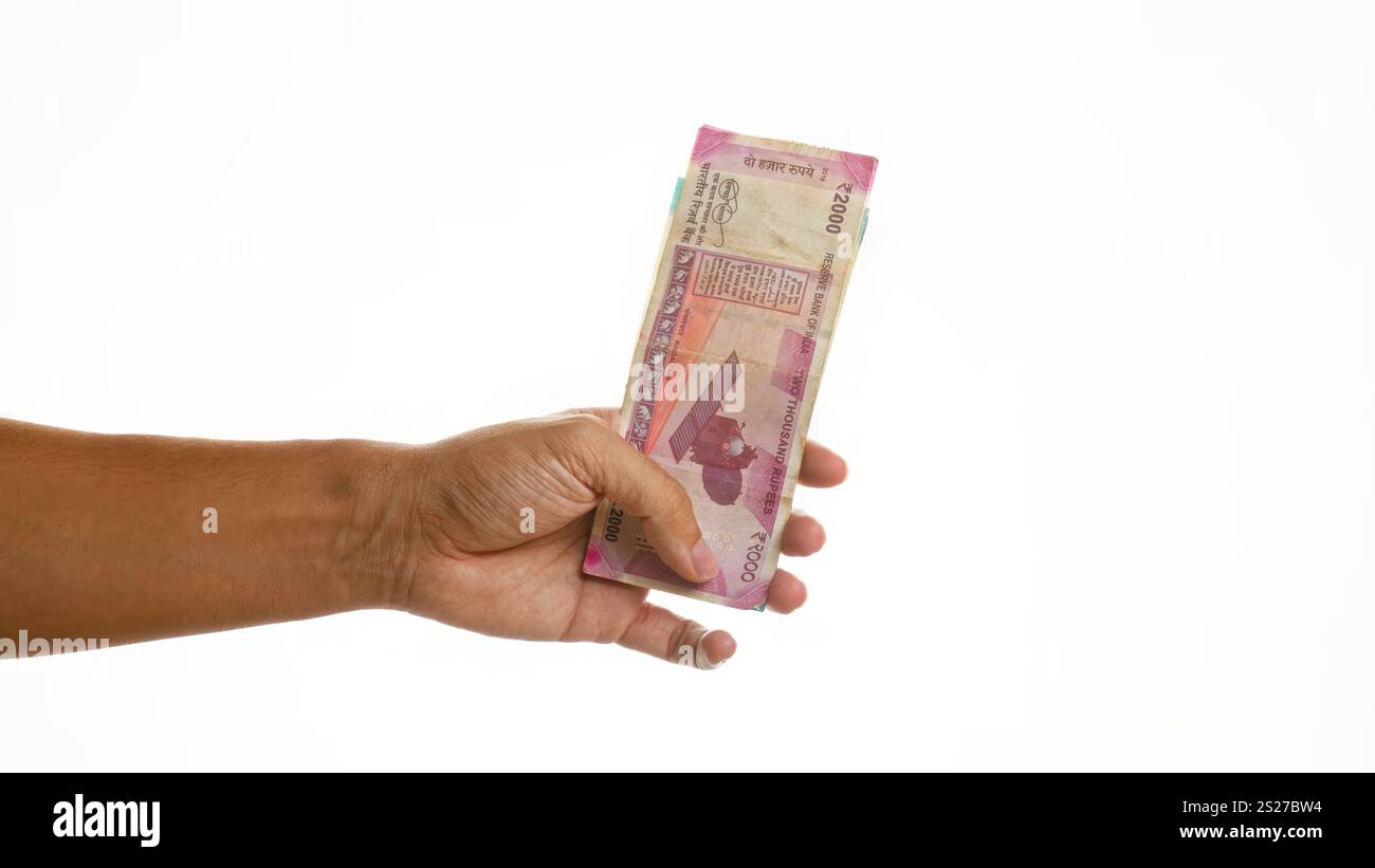 Indian hand holding 2000 rupee notes against a white background ...
