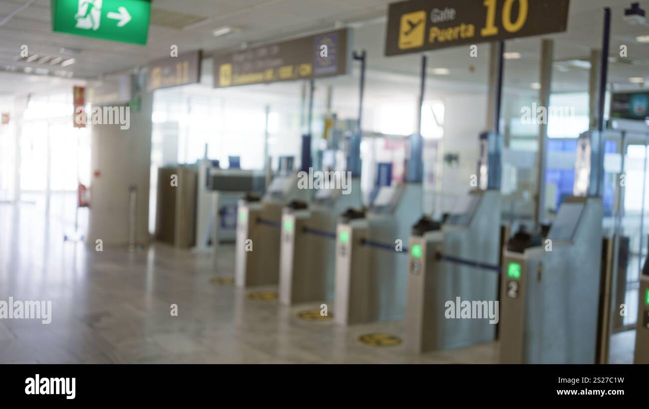 Blurred airport terminal with defocused gates and blurry signage ...