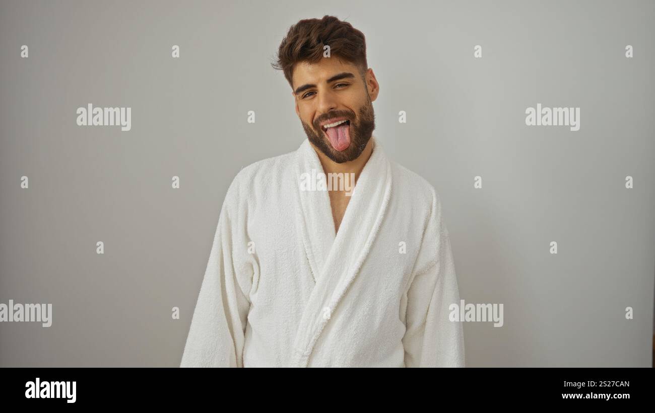 Handsome young hispanic man with beard wearing white robe and sticking ...