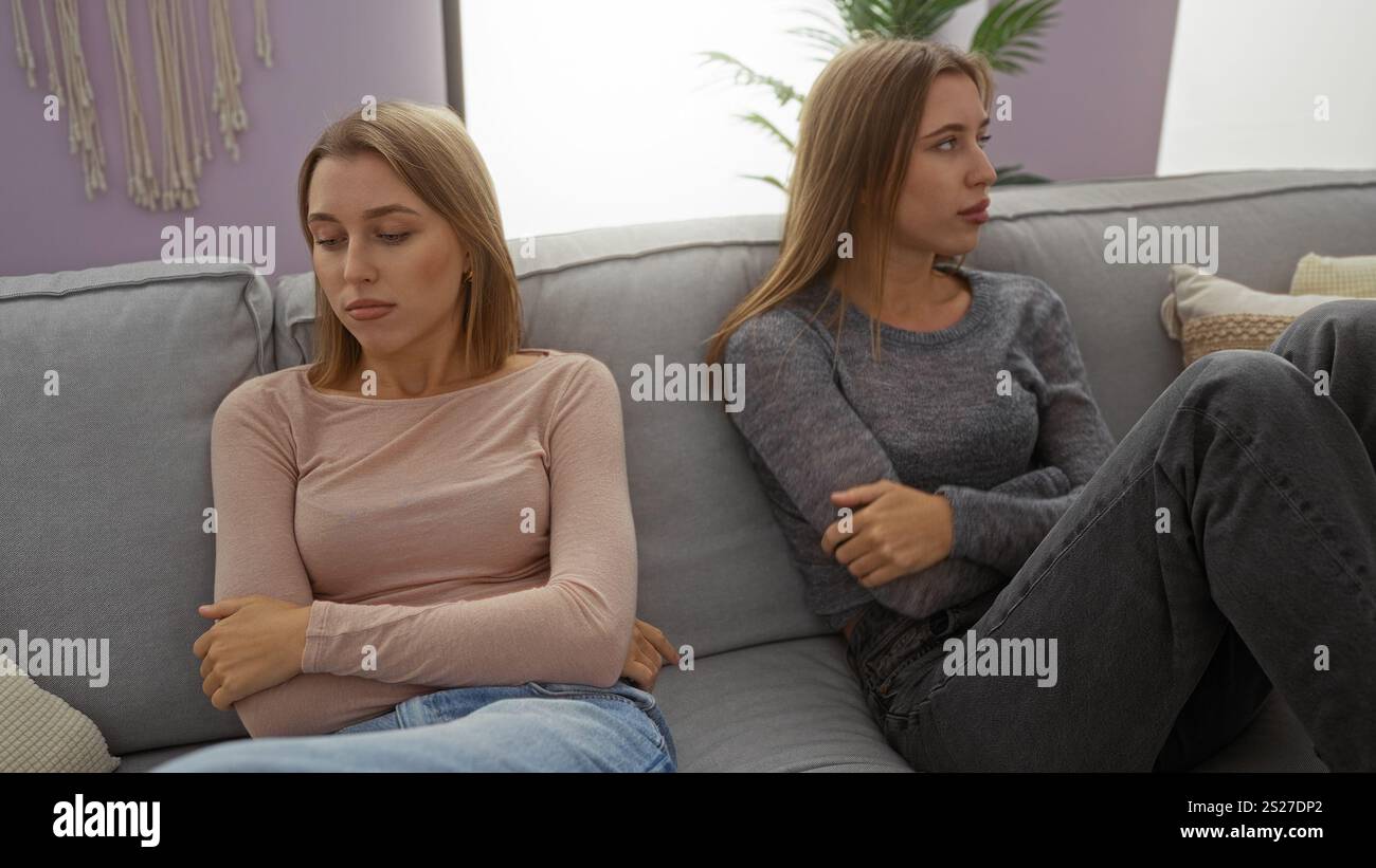 Women with crossed arms sitting on a couch in a living room apartment ...