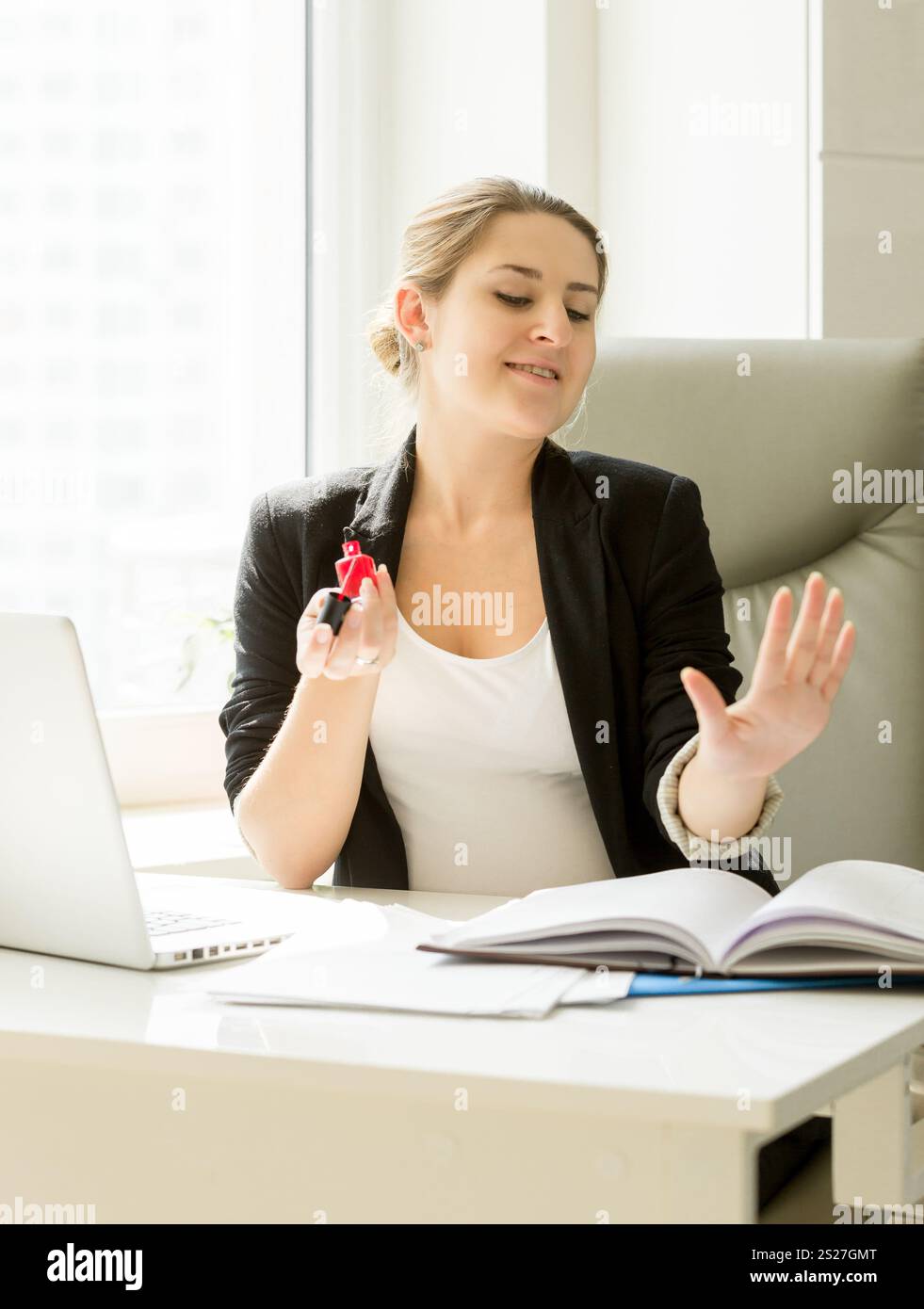 Beautiful young secretary painting fingernails instead of working Stock ...