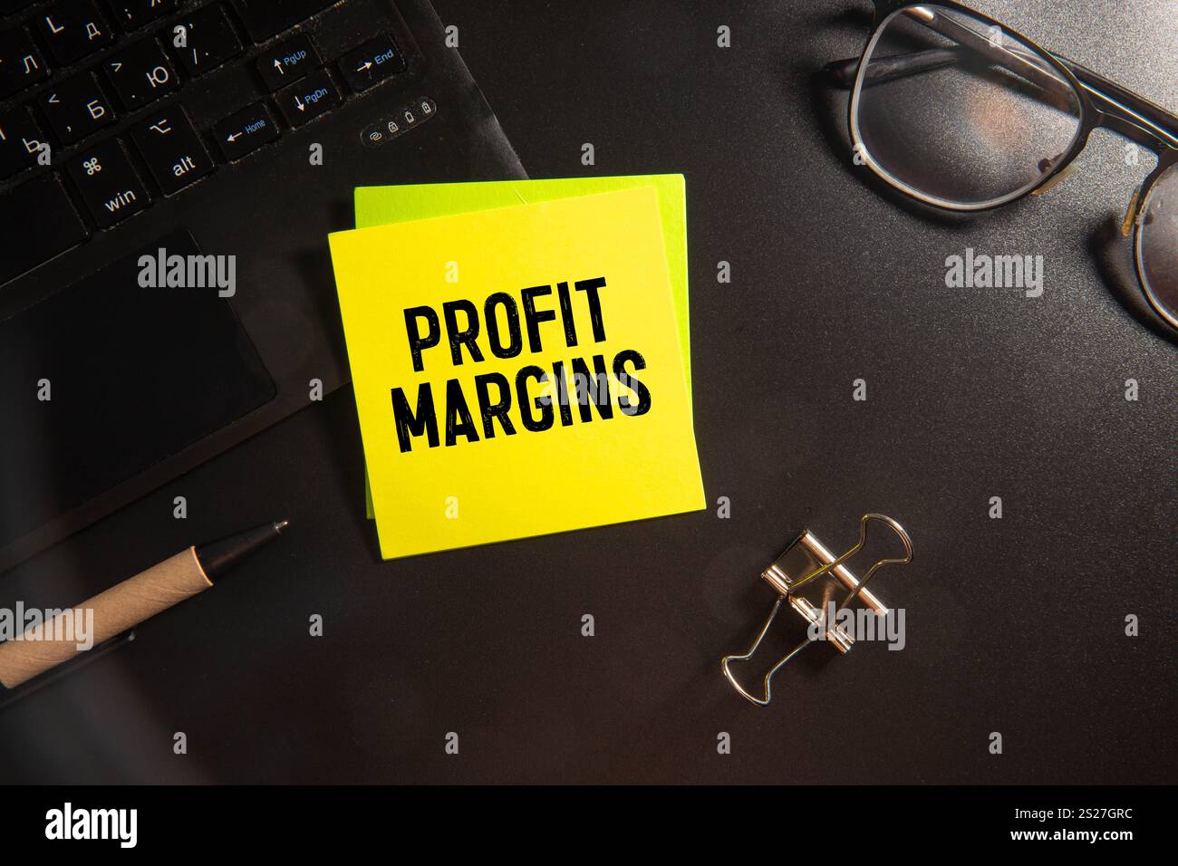 Notepad with text NET PROFIT MARGIN with a pen,office tools and graphs ...