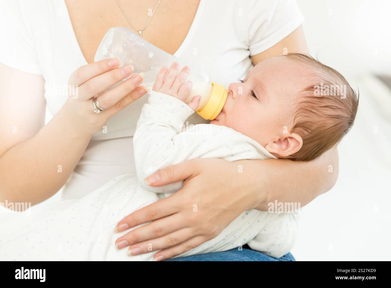 Portrait of mother giving milk from bottle to her baby Stock Photo - Alamy