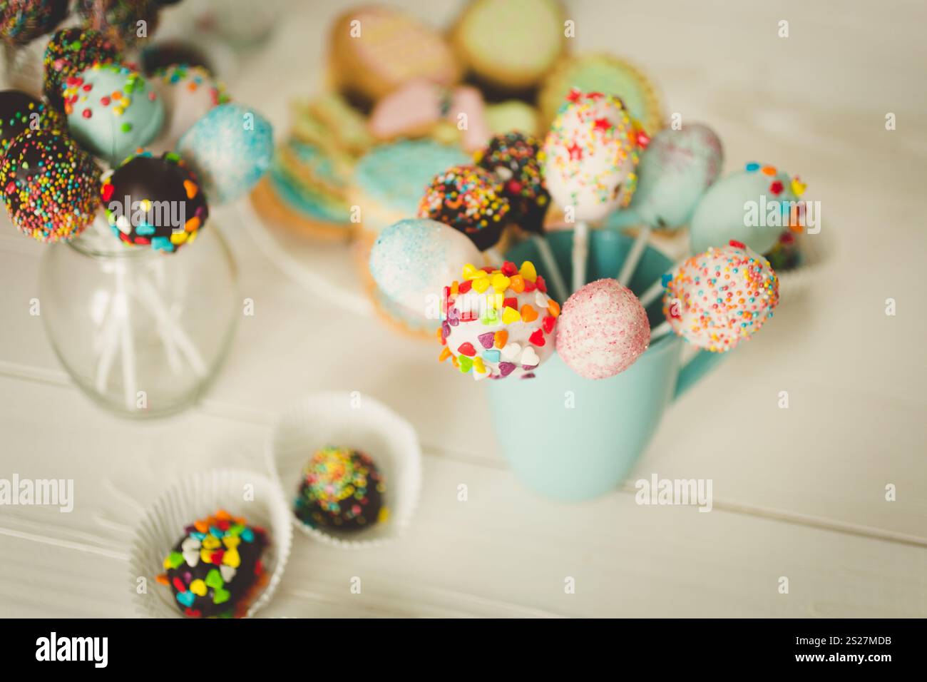 Colorful cake pops in cups on white wooden desk Stock Photo - Alamy