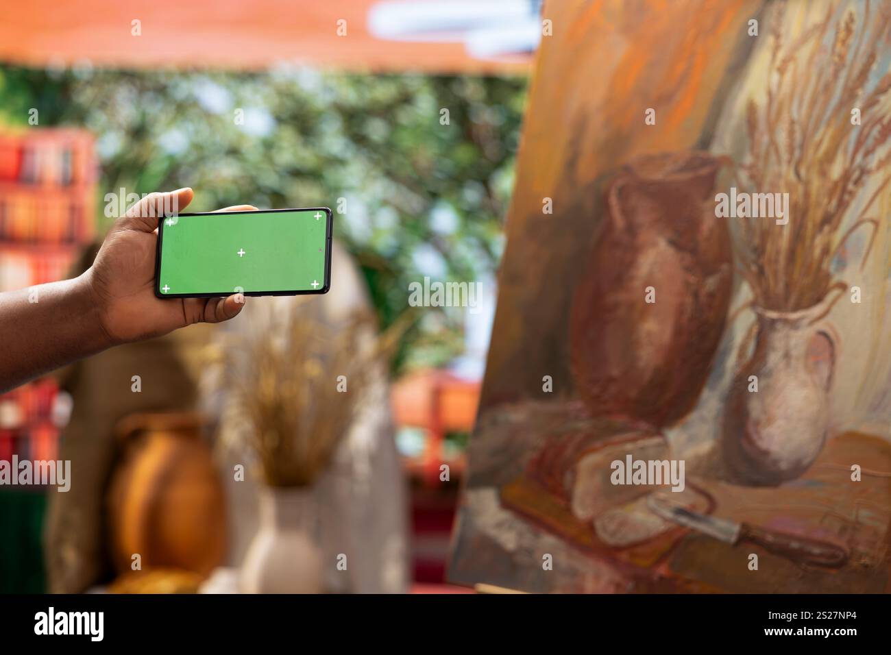 Young artist looking at isolated chroma key display in his painting ...