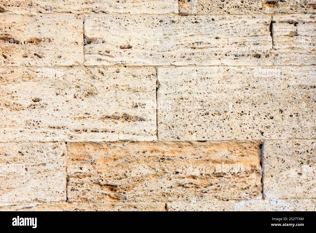 Fragment of a stone wall made of limestone bricks with spongy surface ...