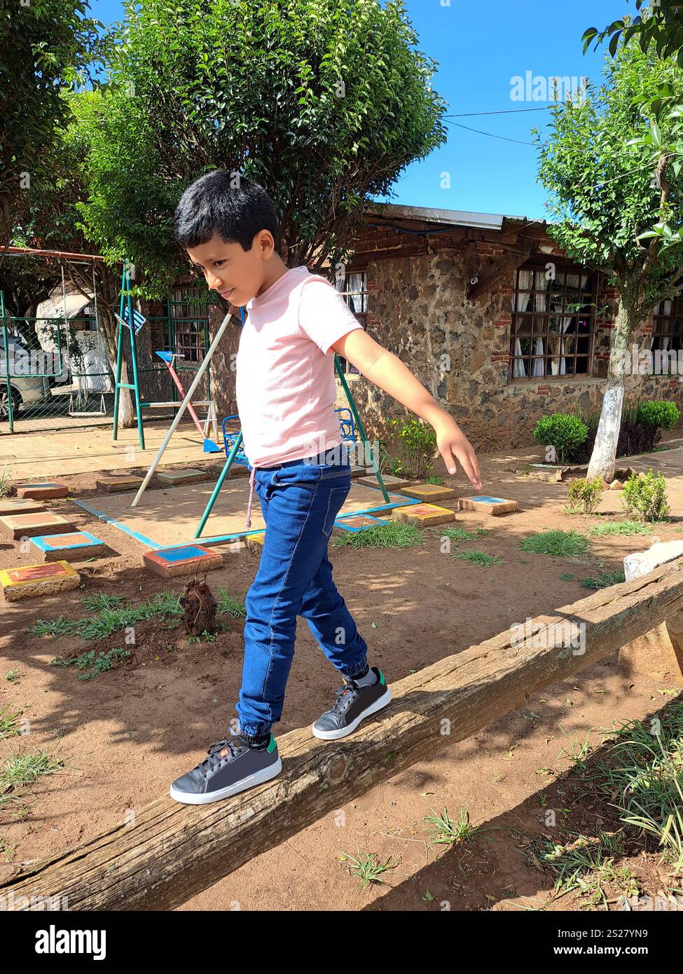 9-year-old dark-skinned Latino male child practices balance exercises ...