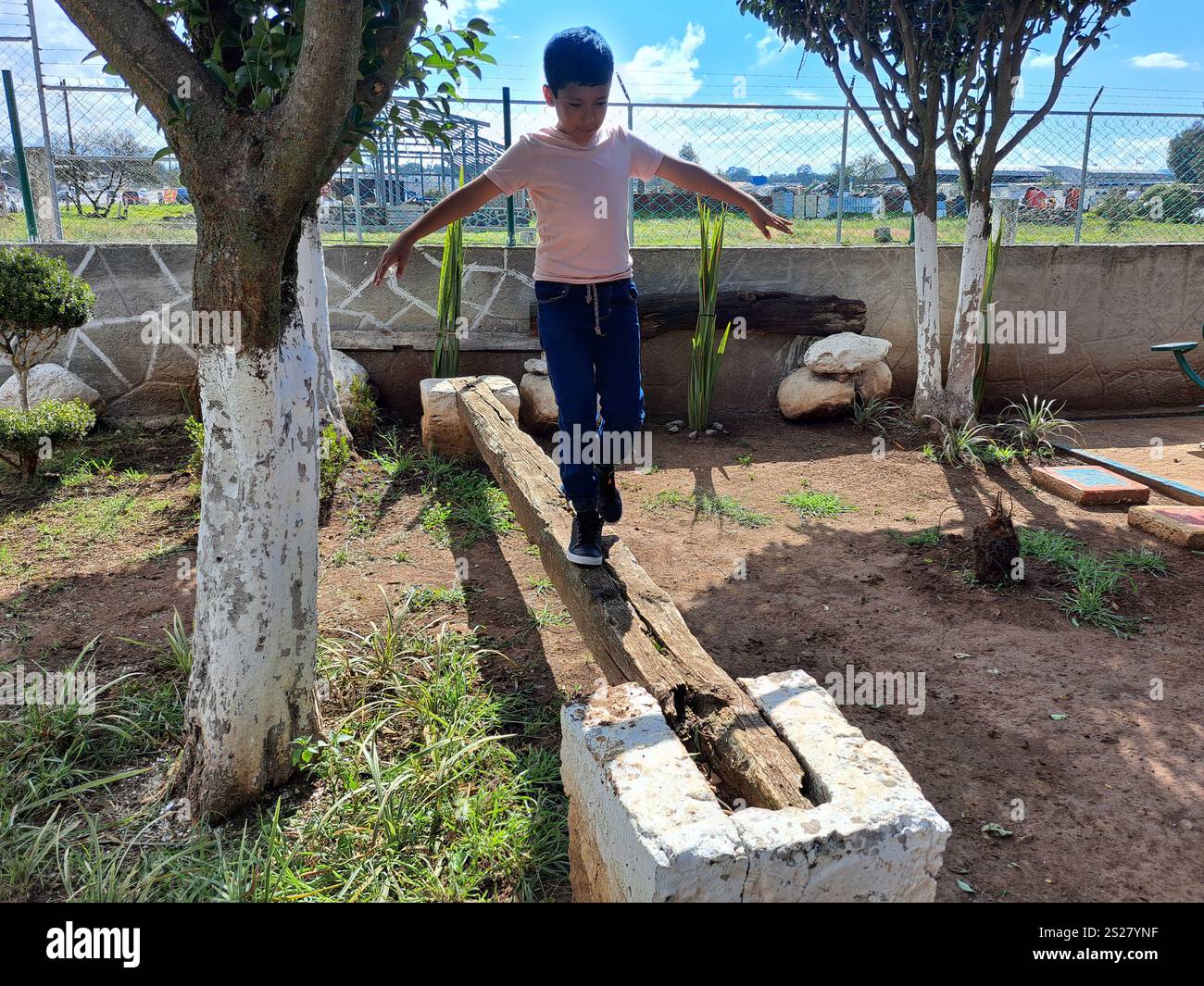 9-year-old dark-skinned Latino male child practices balance exercises ...